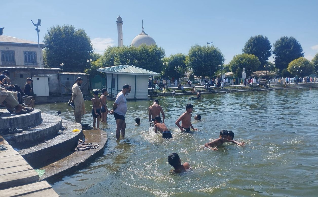 Amid sweltering hot weather conditions children taking bath in the waters of iconic Dal Lake at ...